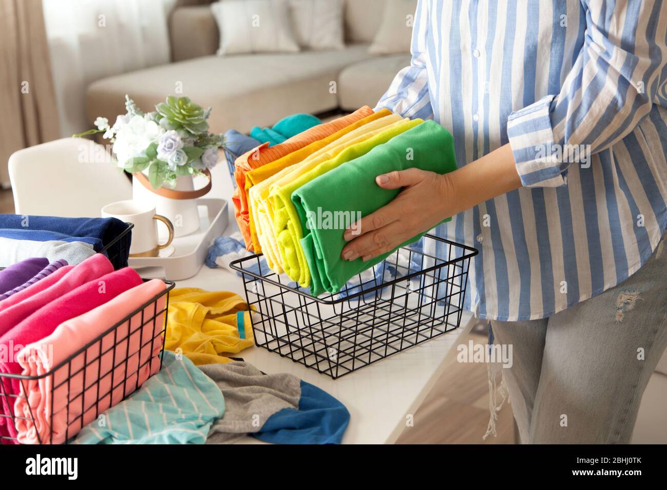 Woman in casual clothes lays clothes in metal mesh Stock Photo - Alamy