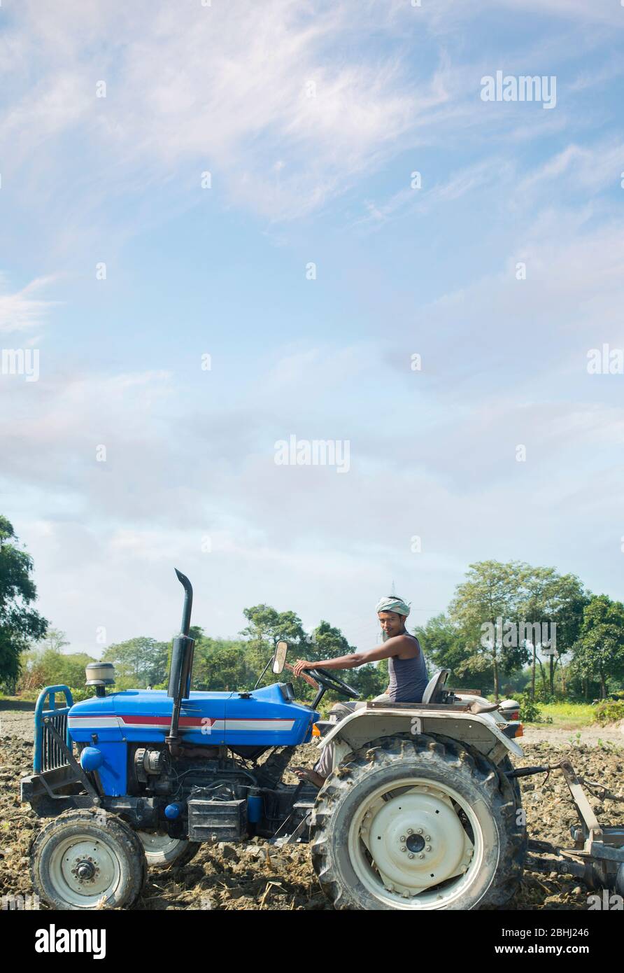 Farmer ploughing a field with tractor Stock Photo - Alamy