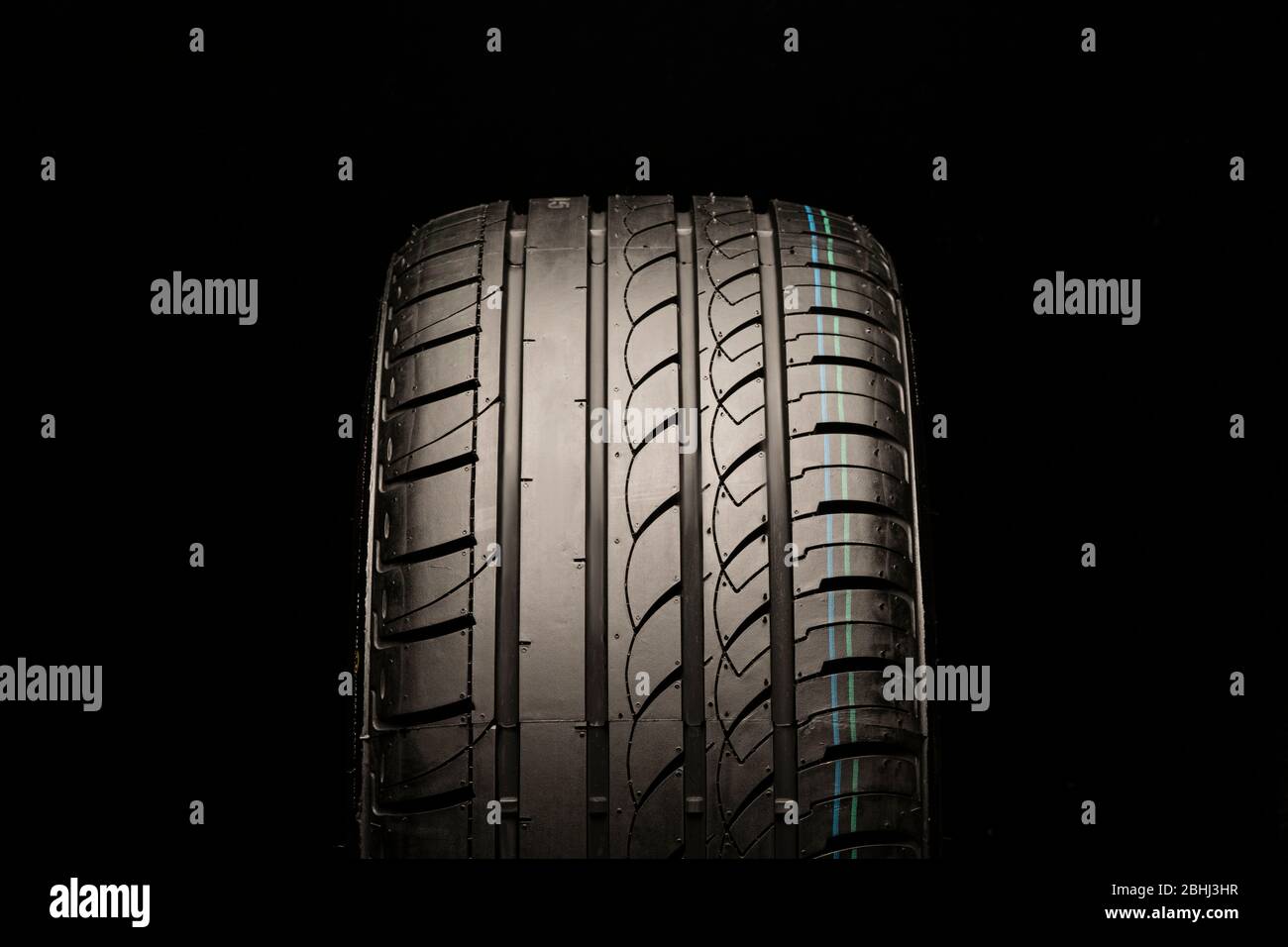 asymmetric summer tire. front view, close-up on a black background ...