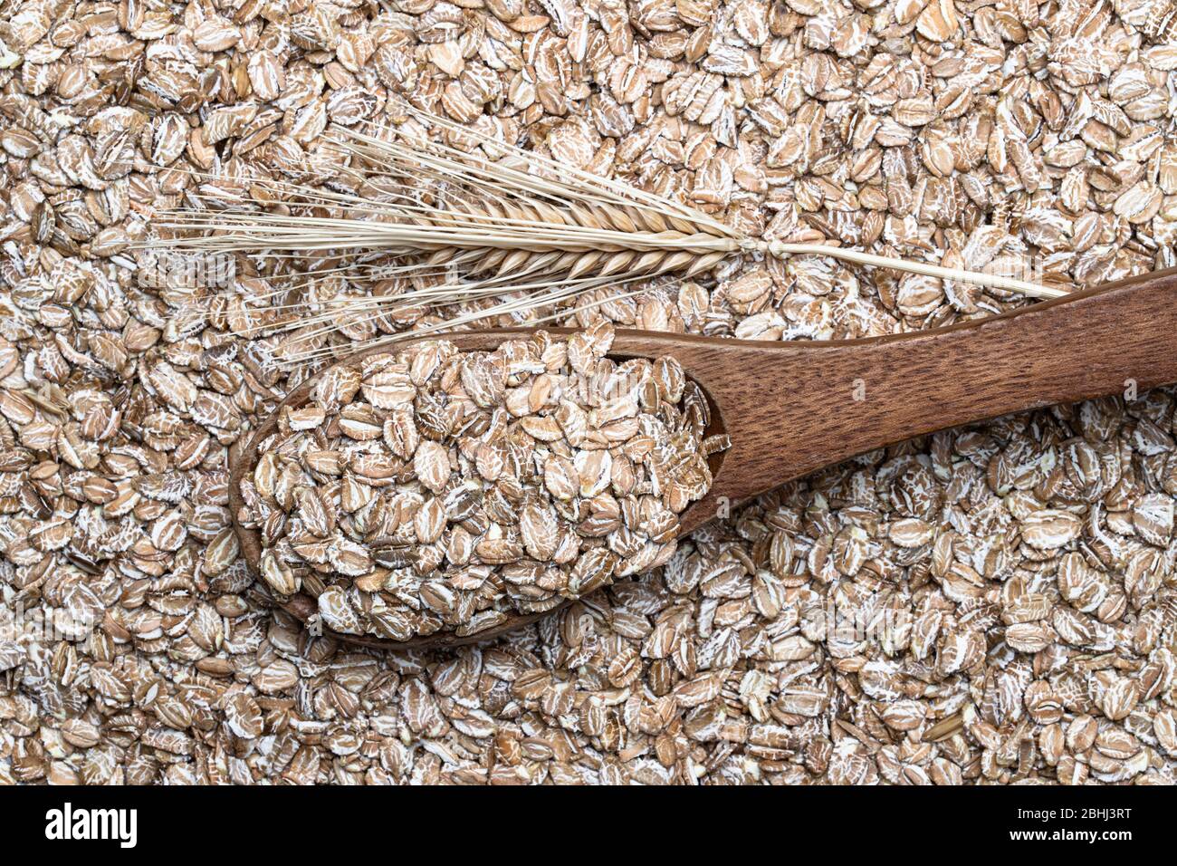 Organic rye flakes in wooden spoon Stock Photo - Alamy