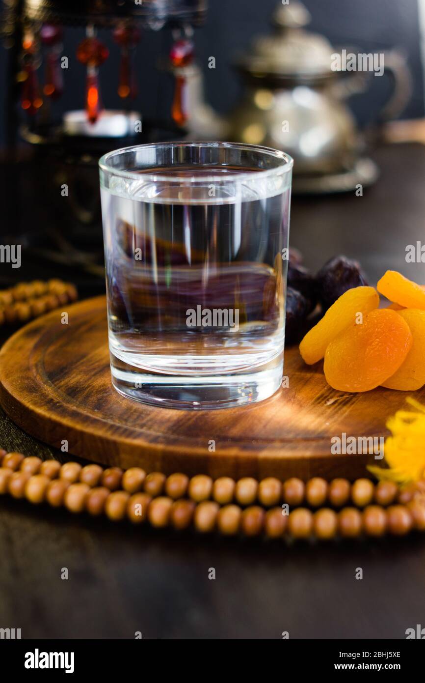 ramadan water for iftar on wooden board with rosary and dried fruits ...