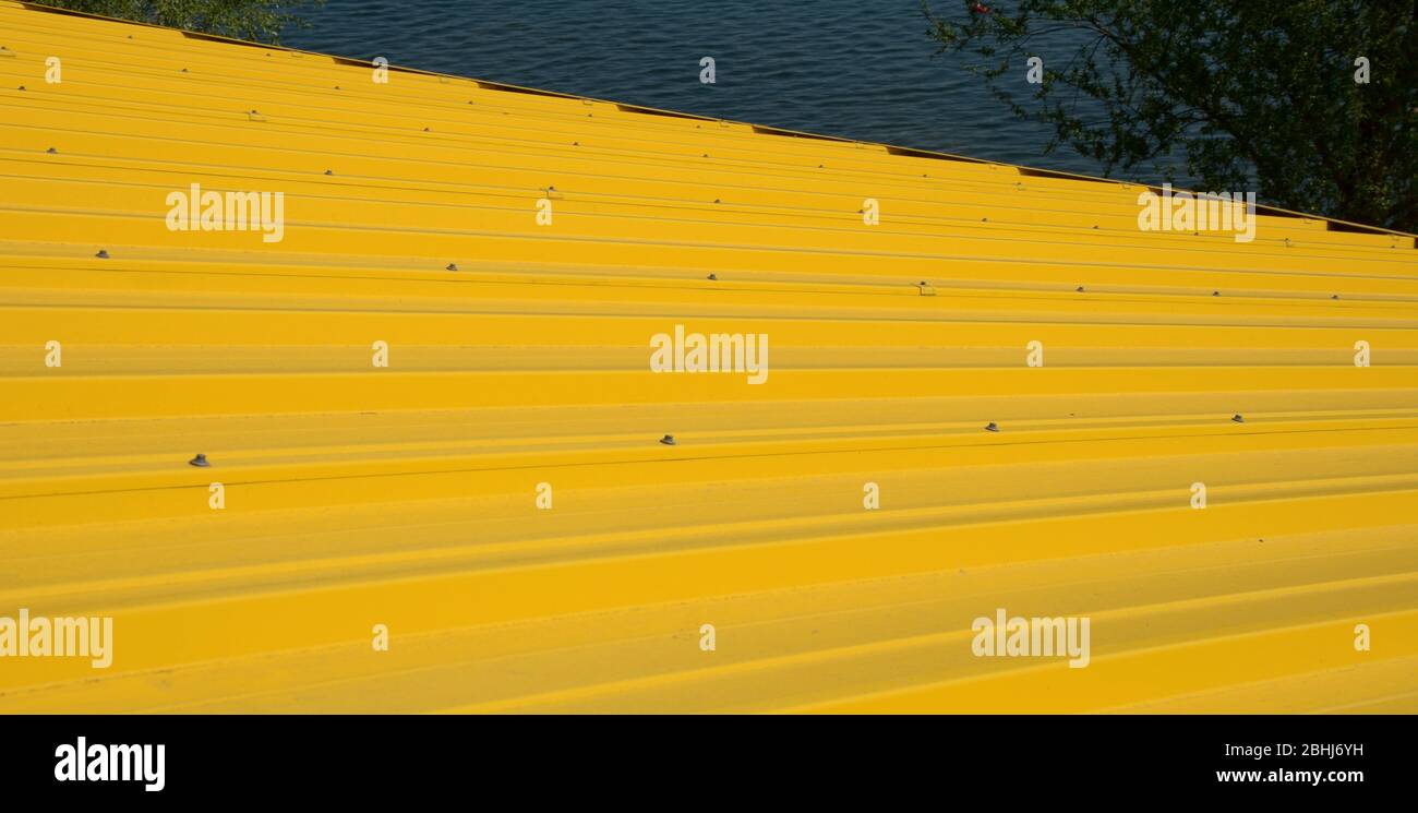 side view of yellow corrugated iron roof lit by sun Stock Photo - Alamy