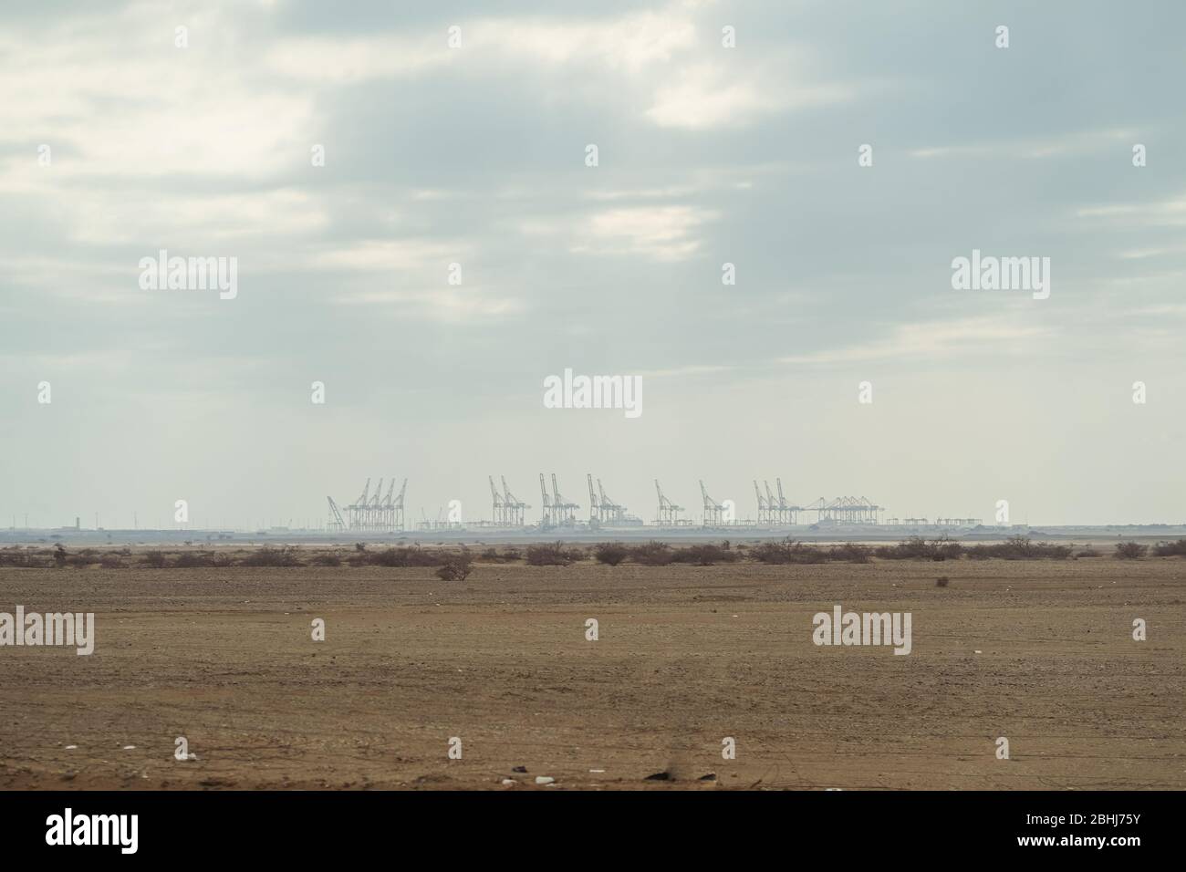 Desert landscape with loading dock cranes protruding against the ...