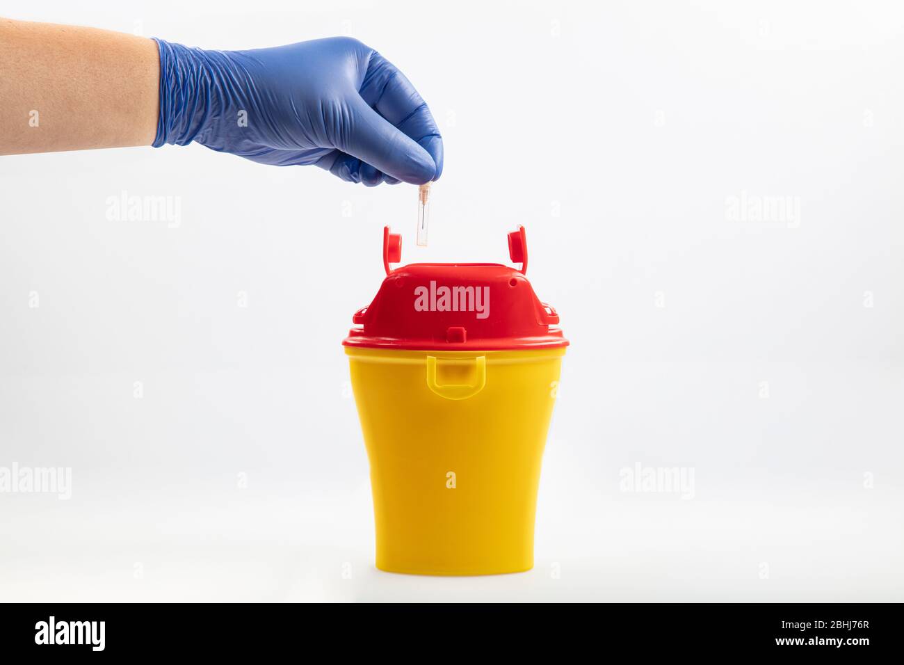 Health worker throws sharp waste into the medical waste bin. Medical ...
