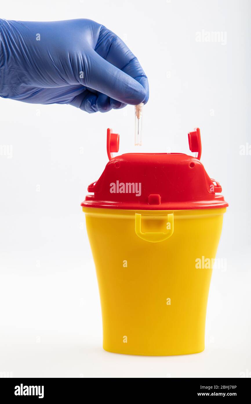 Health worker throws sharp waste into the medical waste bin. Medical ...