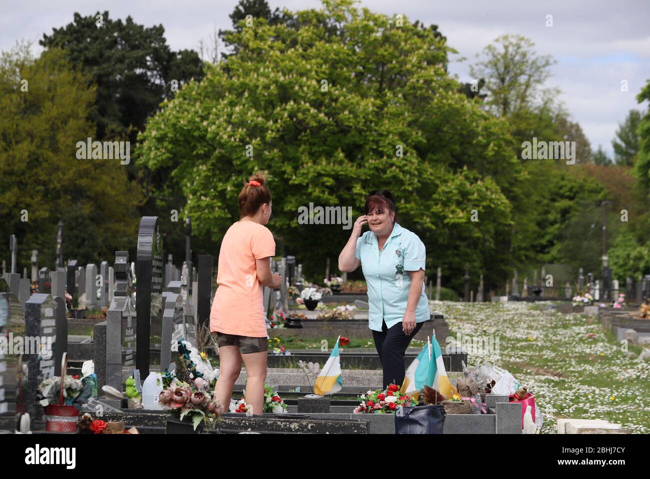 Two women water plants at milltown cemetery in belfast hi-res stock ...