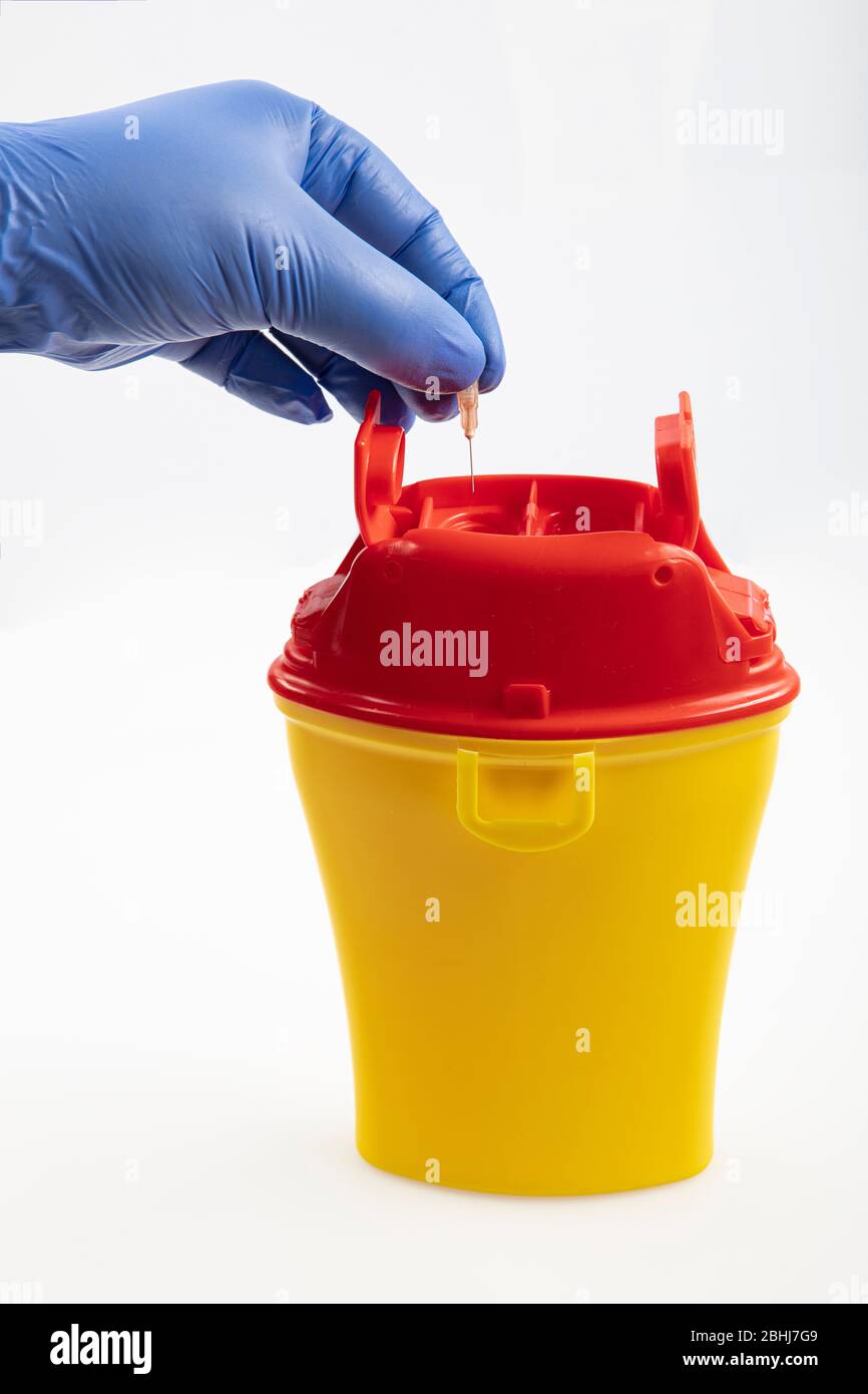 Health worker throws sharp waste into the medical waste bin. Medical ...