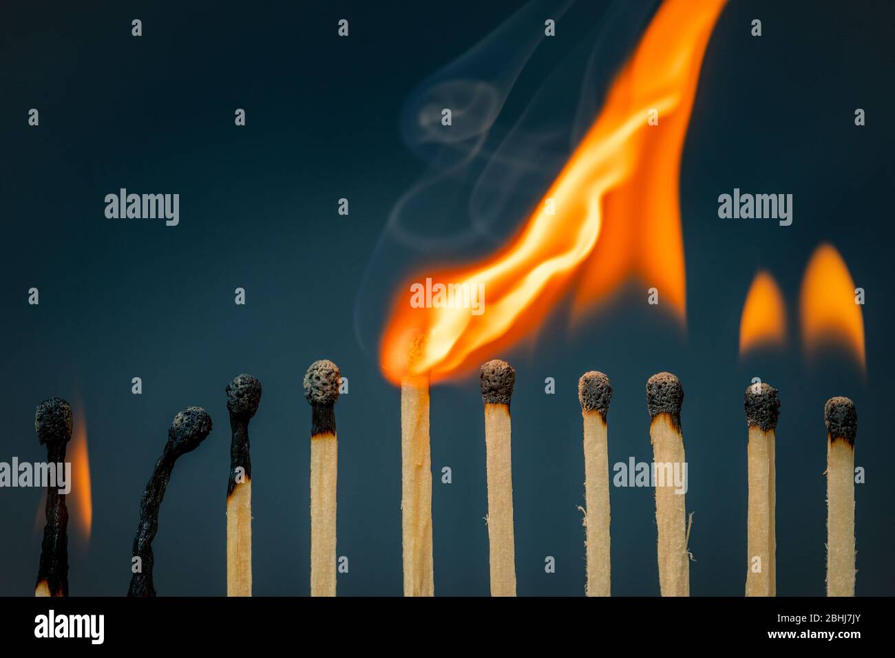 Lighting matches in a row. Matches standing in a row burn in a chain ...