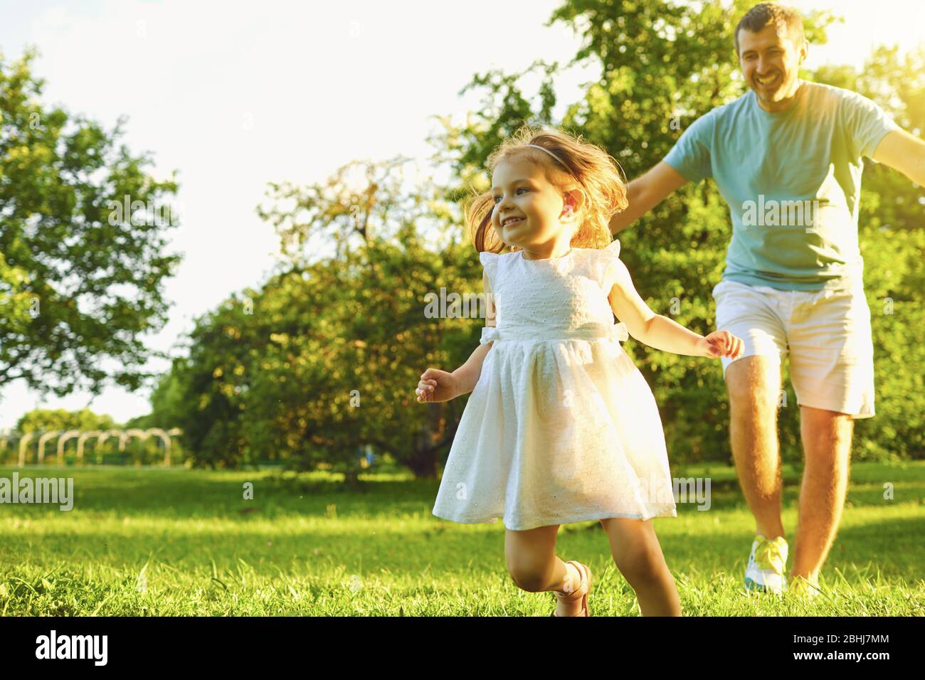 Father's day. Father running plays with his daughter on the grass in ...