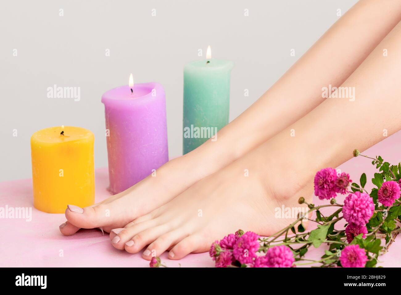 Beautiful female legs with smooth skin decorated with burning candles ...