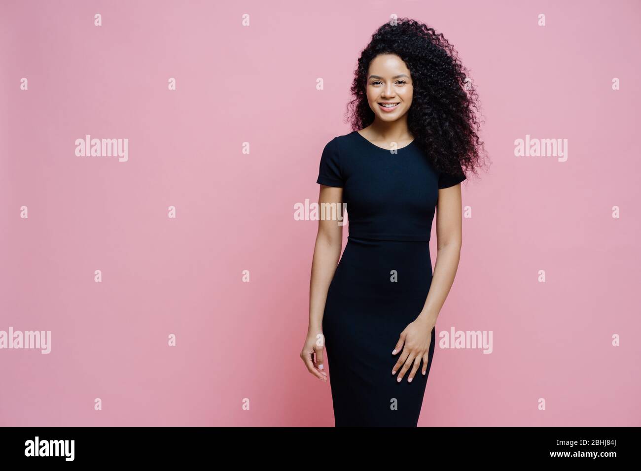 Studio shot of attractive good looking woman in black dress, has slim ...