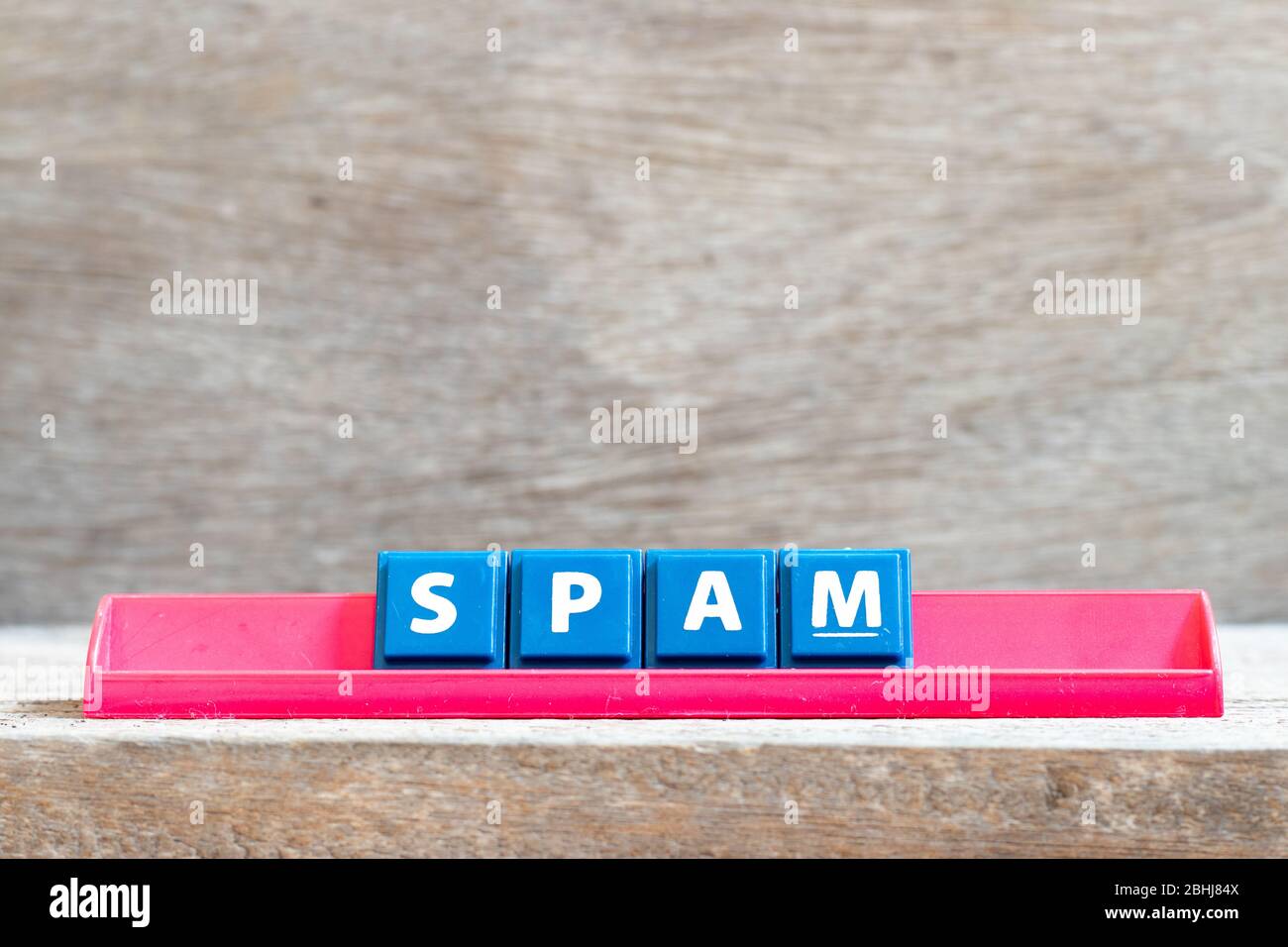 Tile letter on red rack in word spam on wood background Stock Photo - Alamy