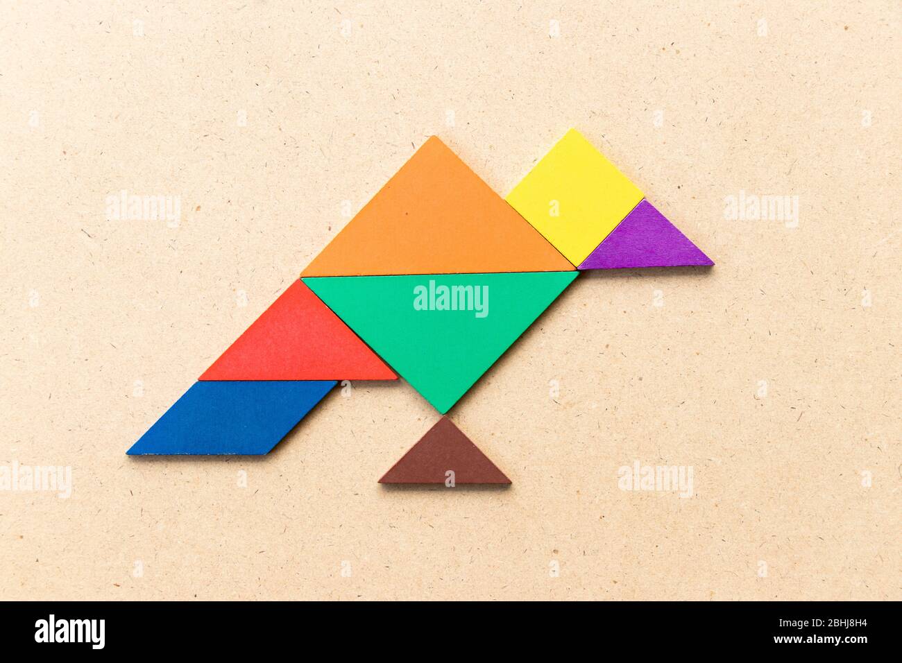 Color tangram puzzle in vulture bird shape on wood background Stock ...