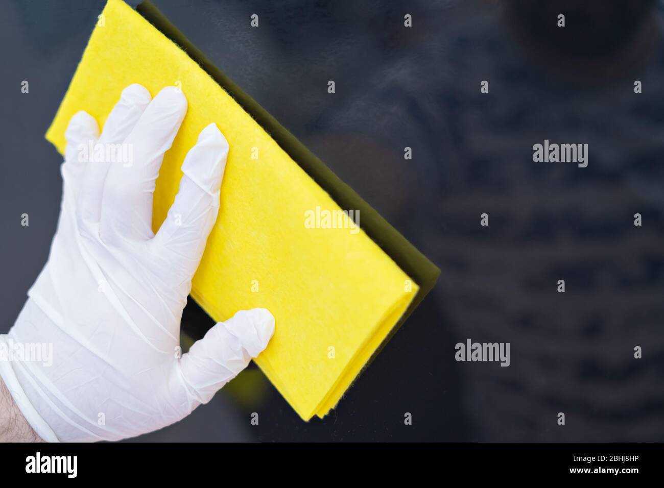 Hand in rubber cleaning glove cleaning surface with cleaning equipment ...