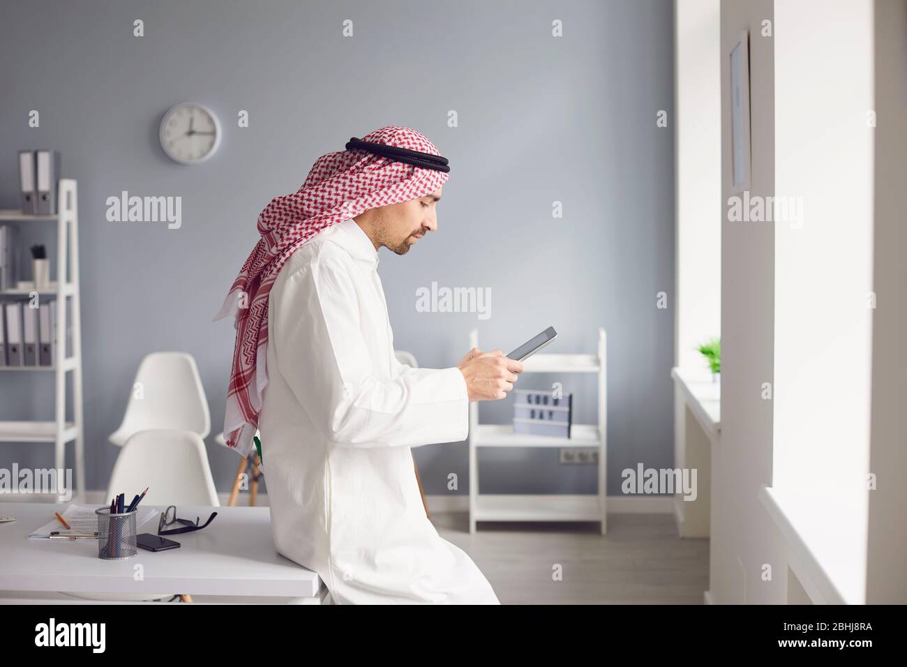 Arab man uses tablet to work online in office. Arabian workplace ...