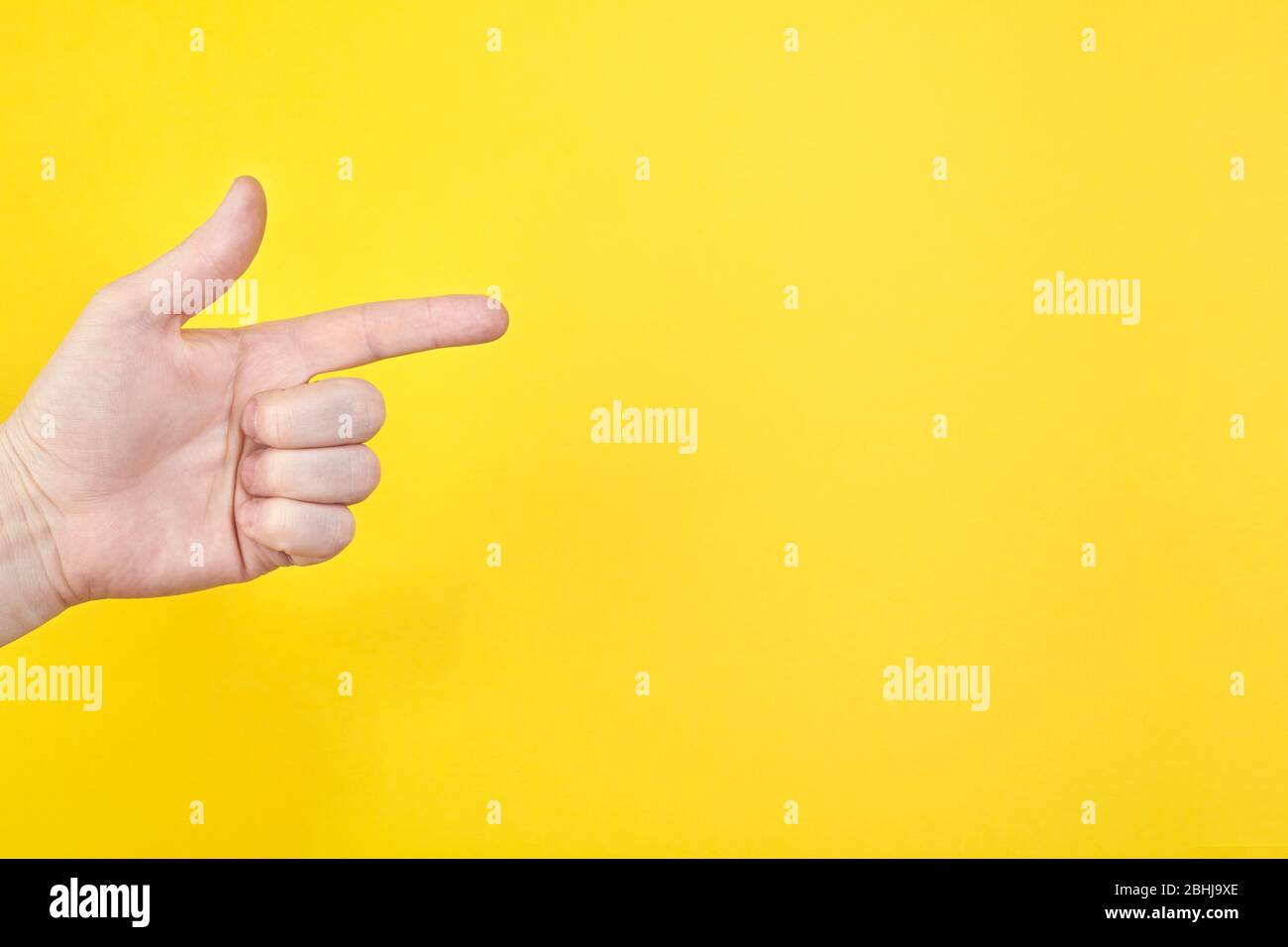 Hand show gesture on an isolated yellow background in studio Stock ...