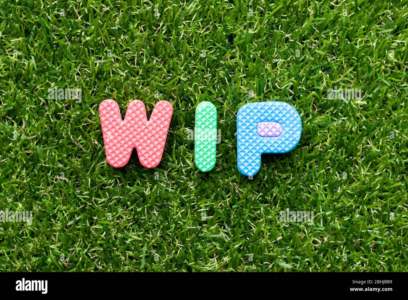 Toy foam letter in word WIP (Abbreviation of work in progress) on green ...