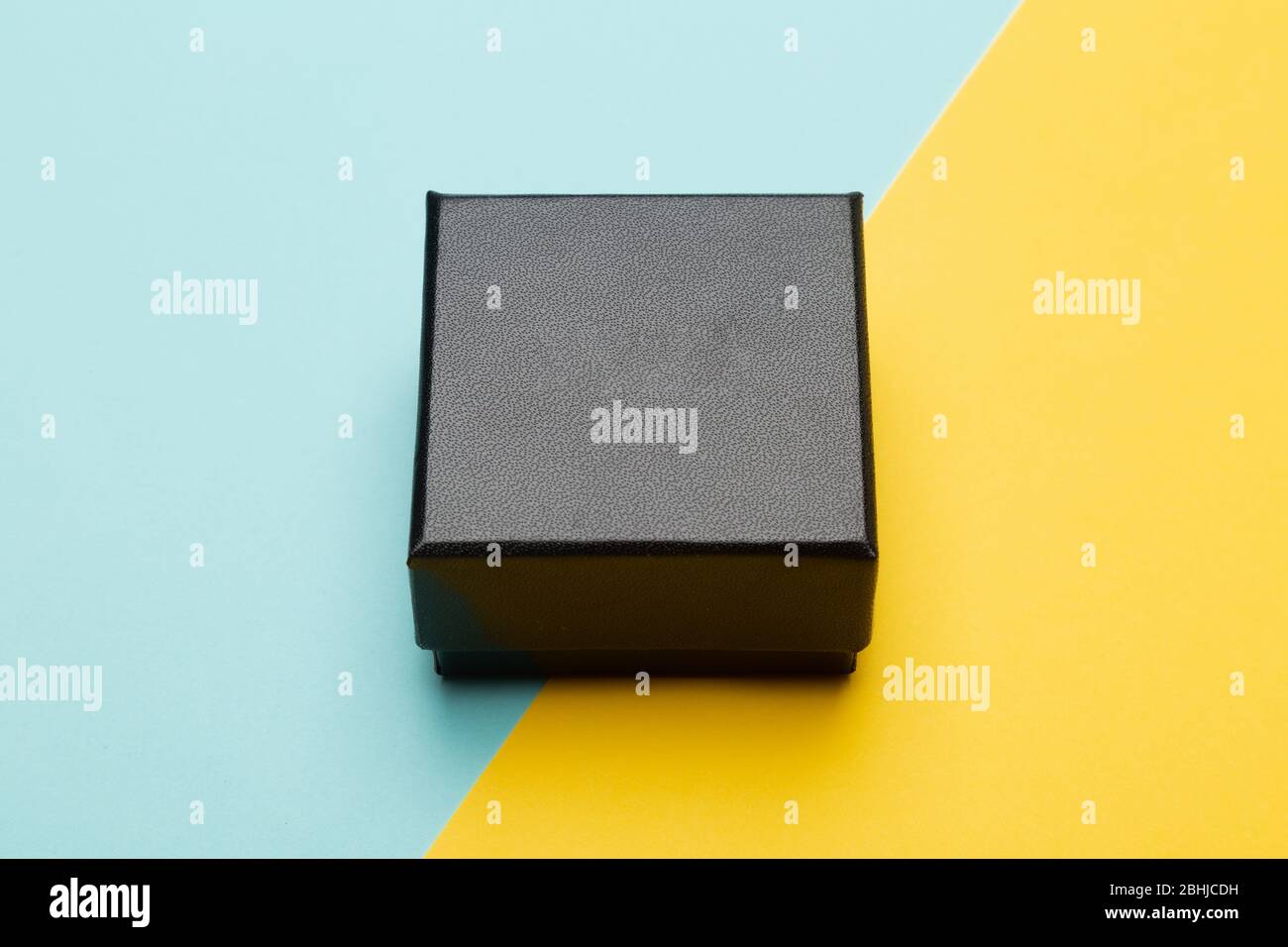 Mini black box product packaging isolated on yellow half blue ...