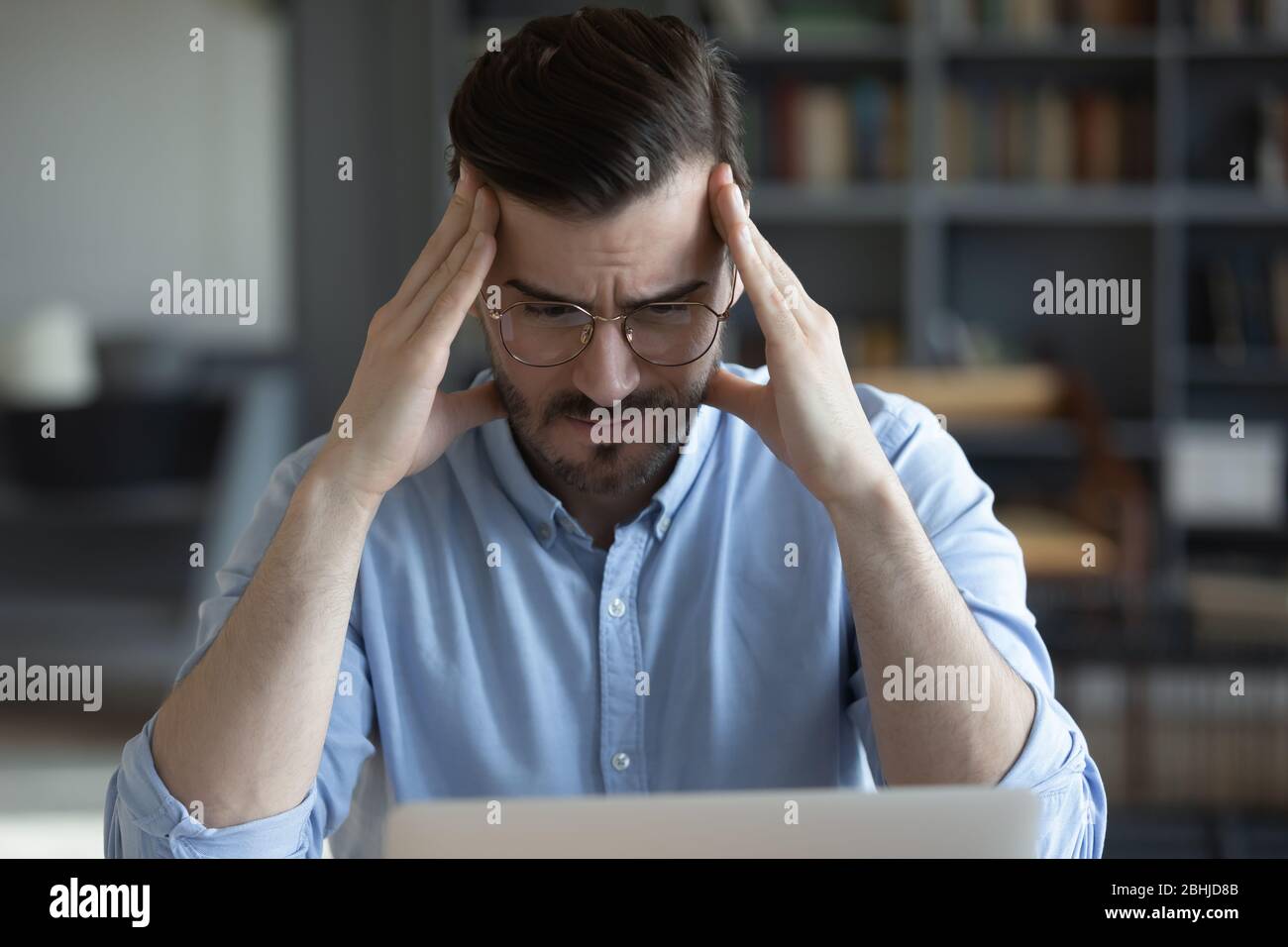 Unhappy tired businessman touching temples, working on difficult task ...