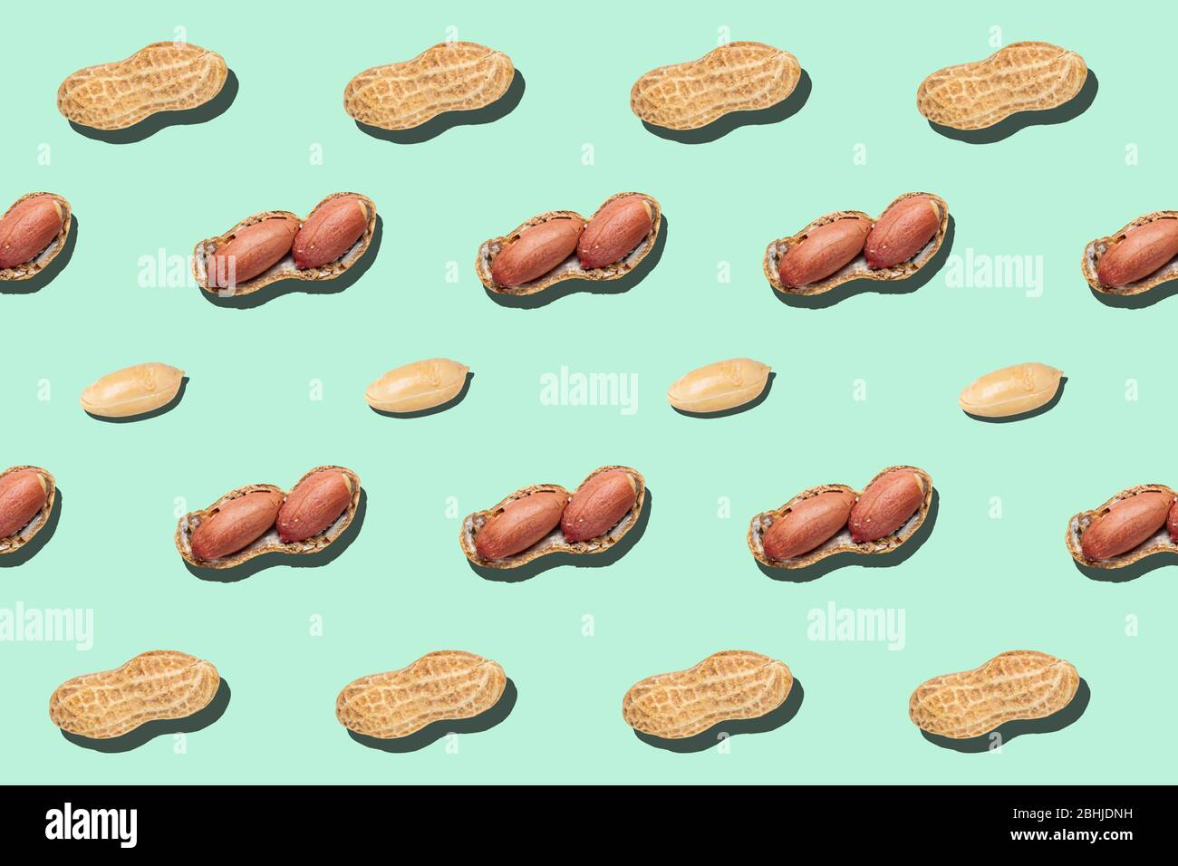 Cracked peanut minimal pattern on light green background backdrop food ...