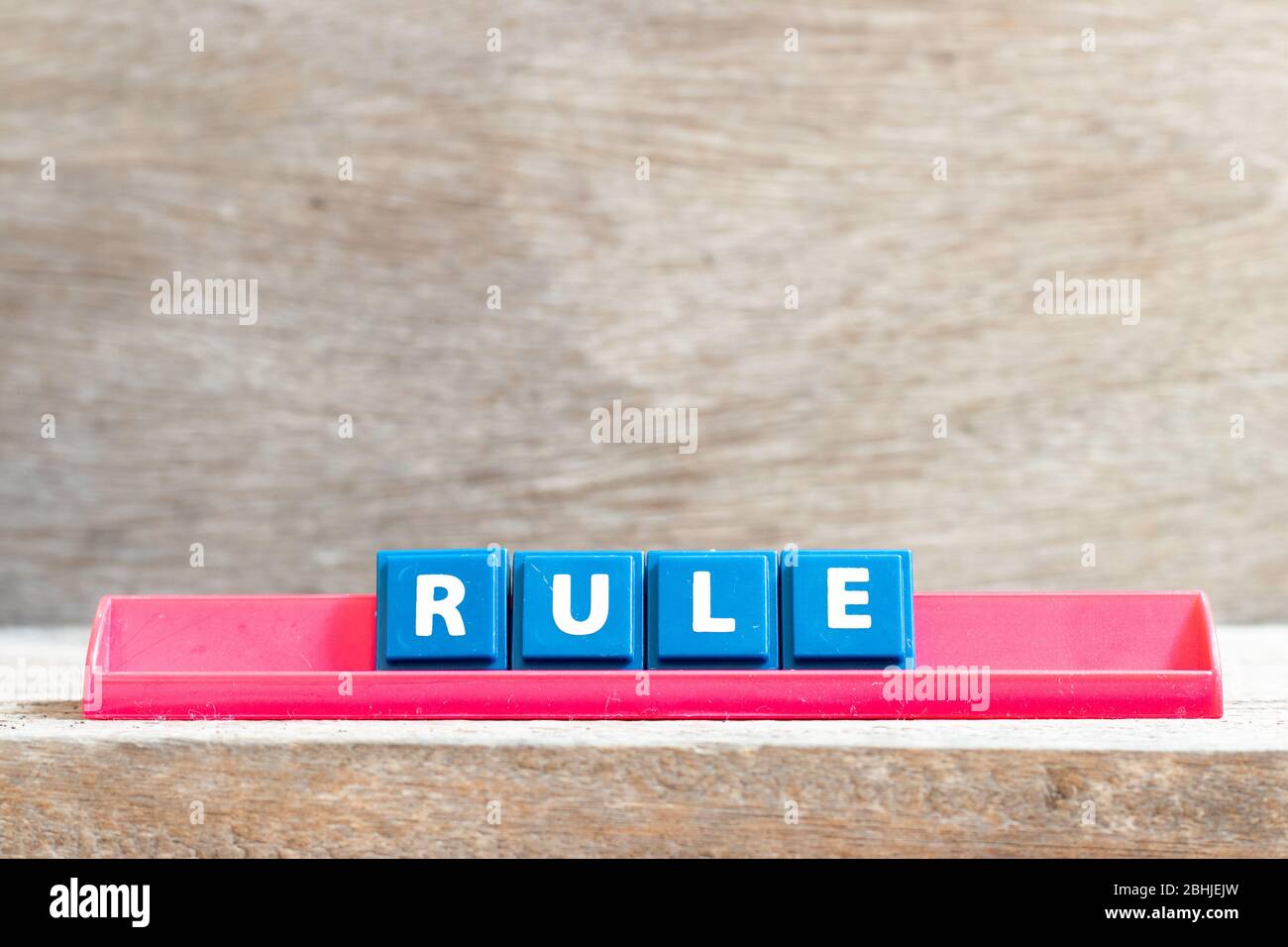 Tile letter on red rack in word rule on wood background Stock Photo - Alamy