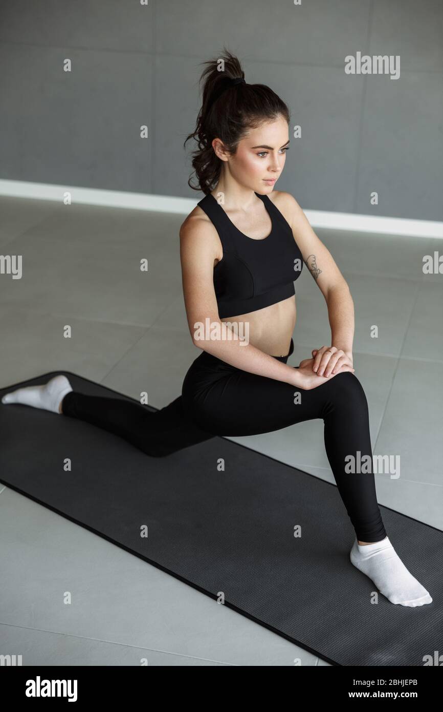 Photo of caucasian beautiful woman in sportswear doing exercise while ...