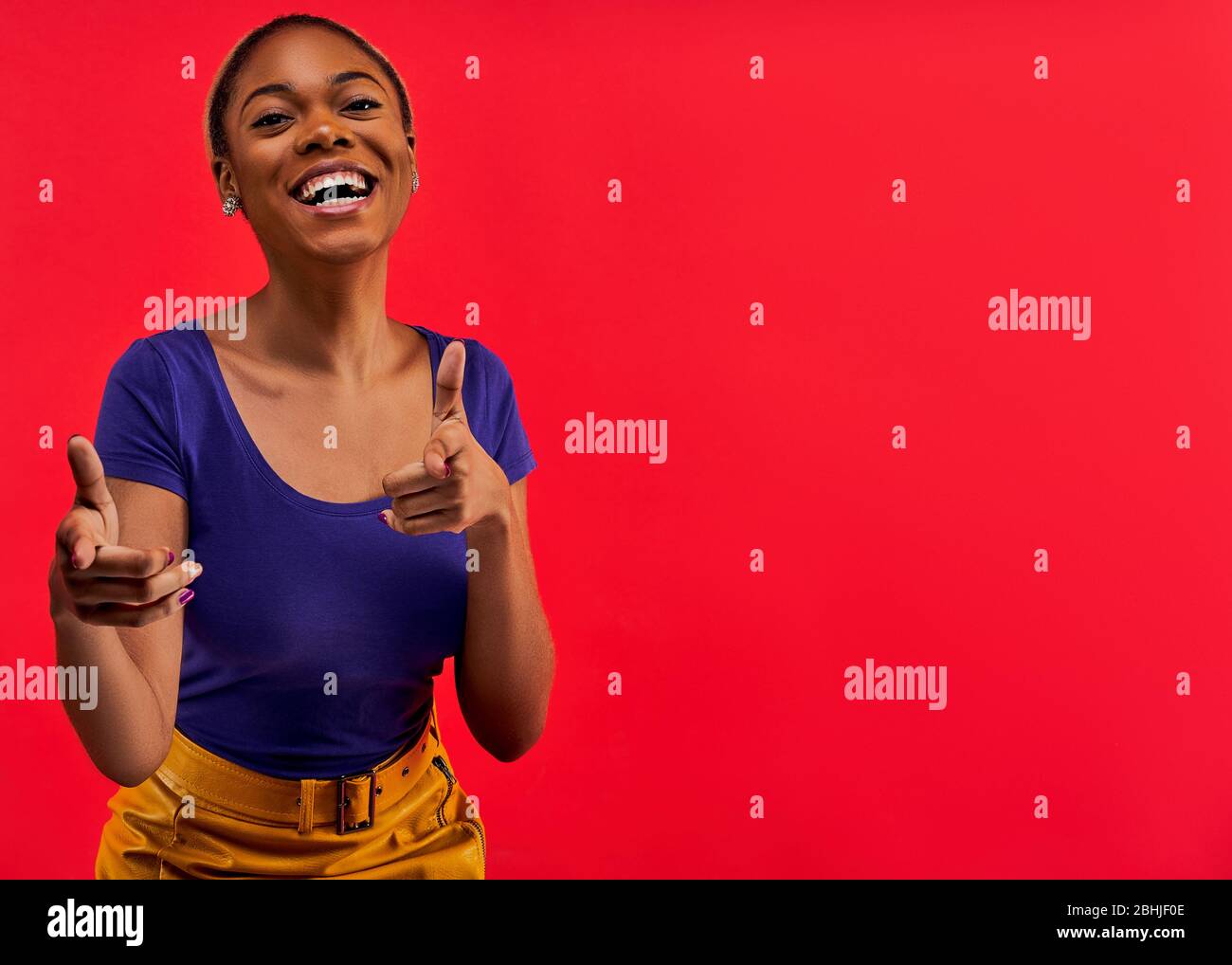 Girl with a wide smile points to the viewer Stock Photo - Alamy