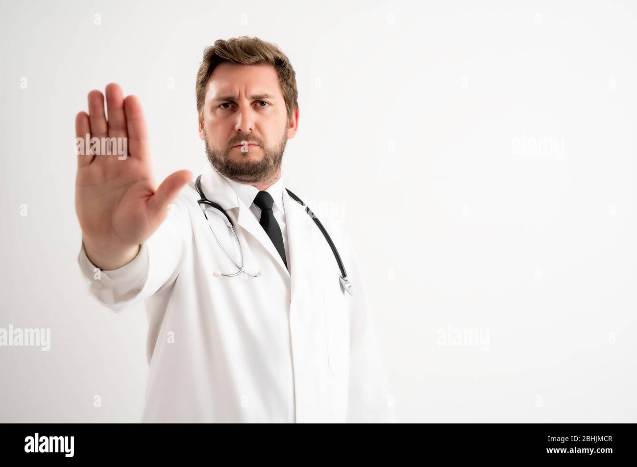 Portrait of male doctor with stethoscope in medical uniform showing ...