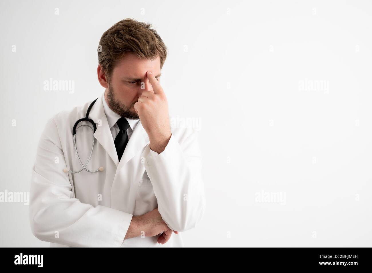 Portrait of male doctor with stethoscope in medical uniform wondering ...