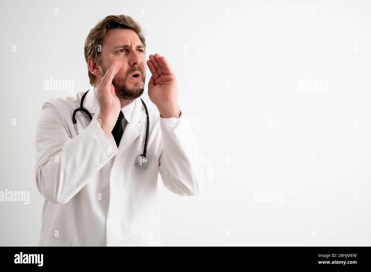 Portrait of male doctor with stethoscope in medical uniform shouting ...
