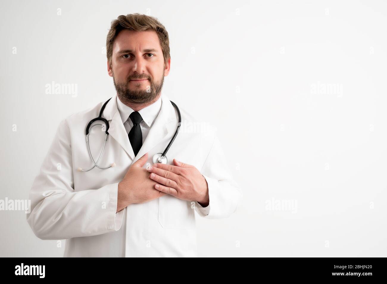 Portrait of male doctor with stethoscope in medical uniform holds her ...