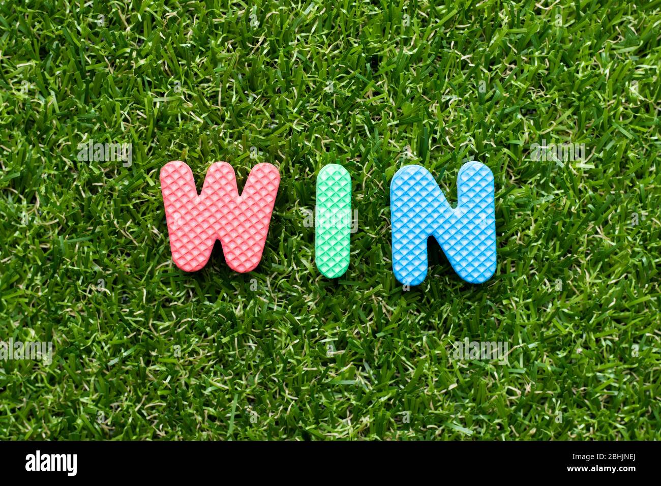 Toy foam letter in word win on green grass background Stock Photo - Alamy