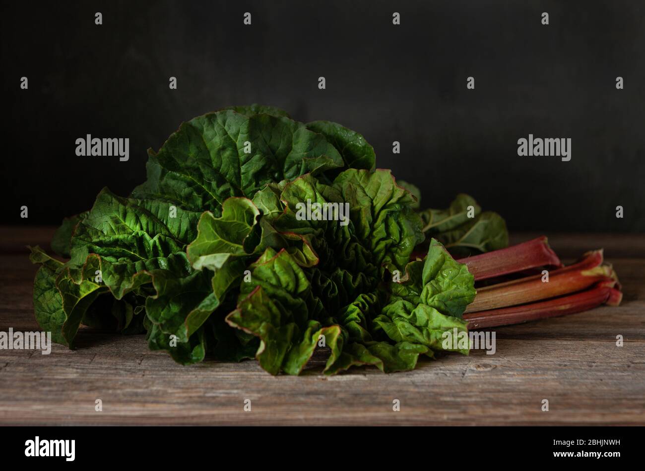 Bunch of fresh picked organic rhubarb on wooden background Stock Photo ...