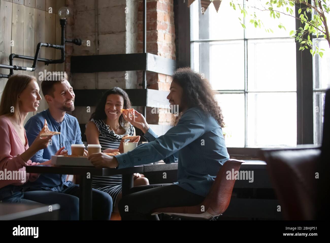 Happy diverse friends have fun eating out in pizzeria Stock Photo - Alamy