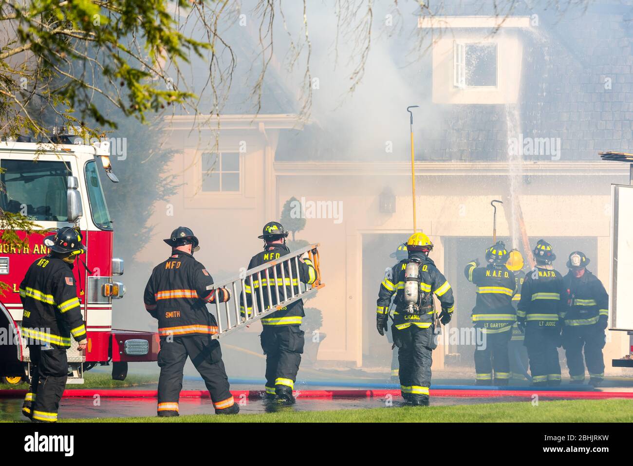 Group of firefighters walking towards the house to battle a fire at 84 ...