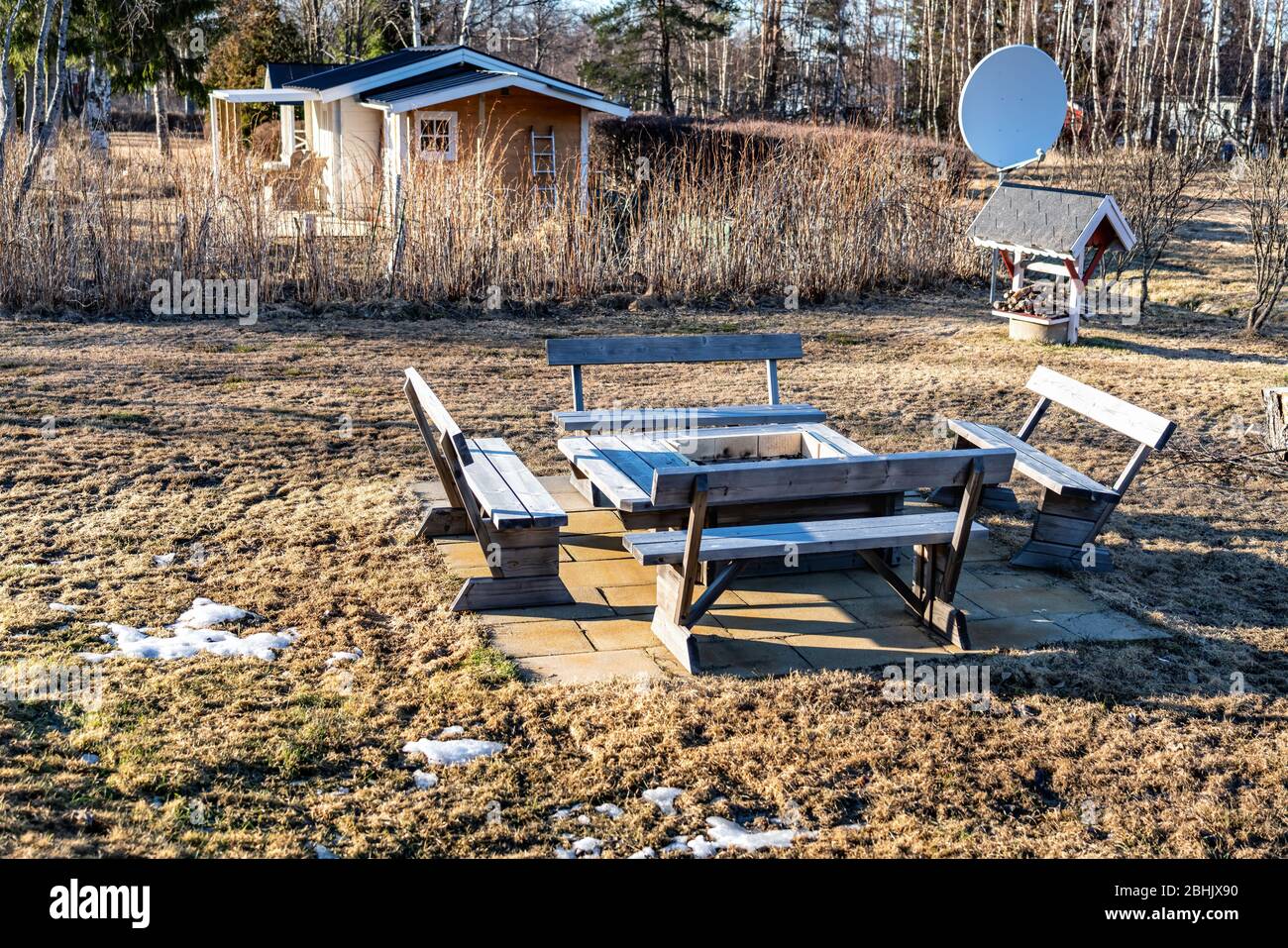 Stylish wooden barbeque spot with benches and table standing at ...