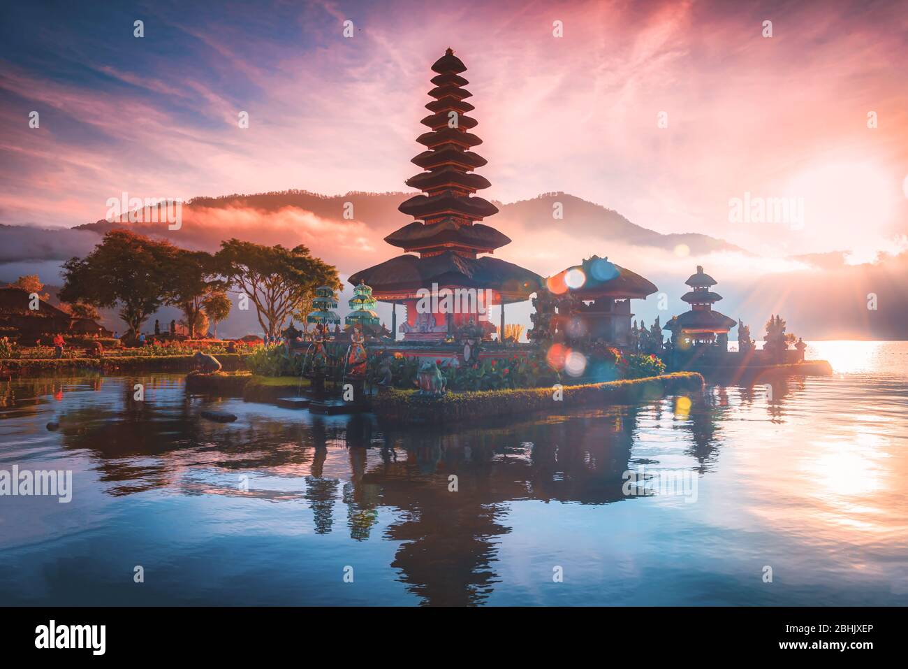 Pura Ulun Danu Bratan, Hindu temple on Bratan lake landscape with lens flare at sunrise in Bali ...