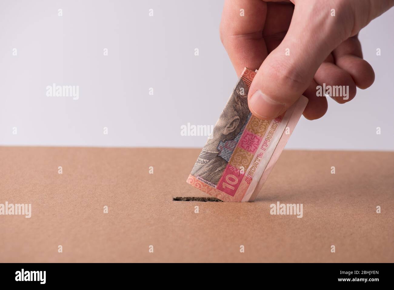 Person putting money in charity box hi-res stock photography and images ...