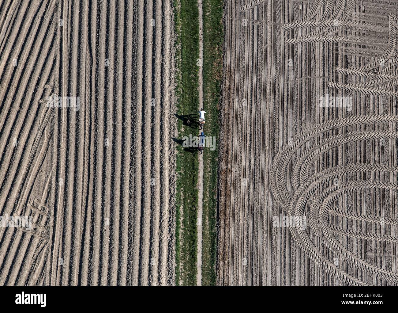 Marl, Germany. 26th Apr, 2020. Two cyclists with a dog are on the road ...