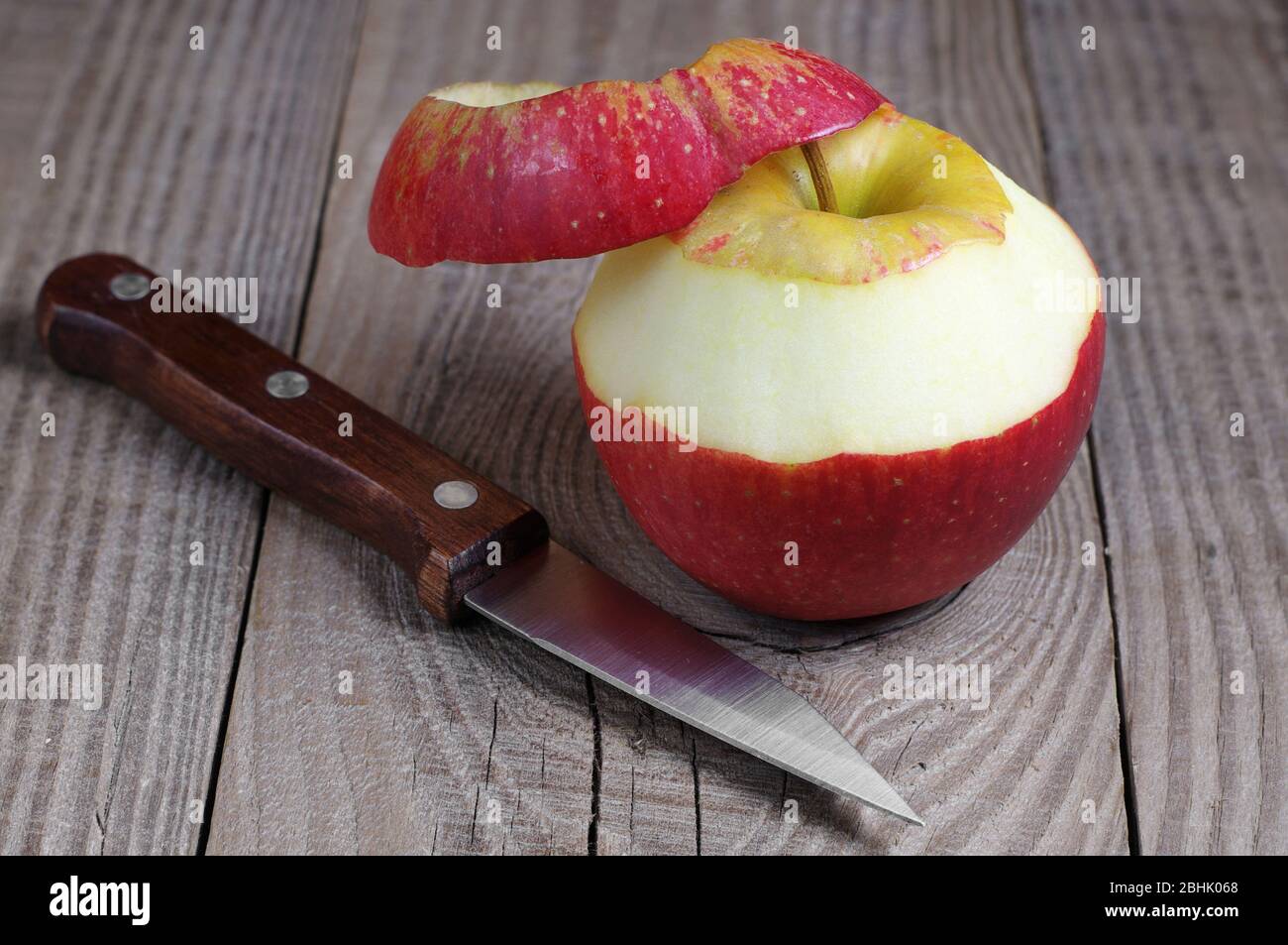 Peeled red apple and knife on rustic wooden table Stock Photo - Alamy