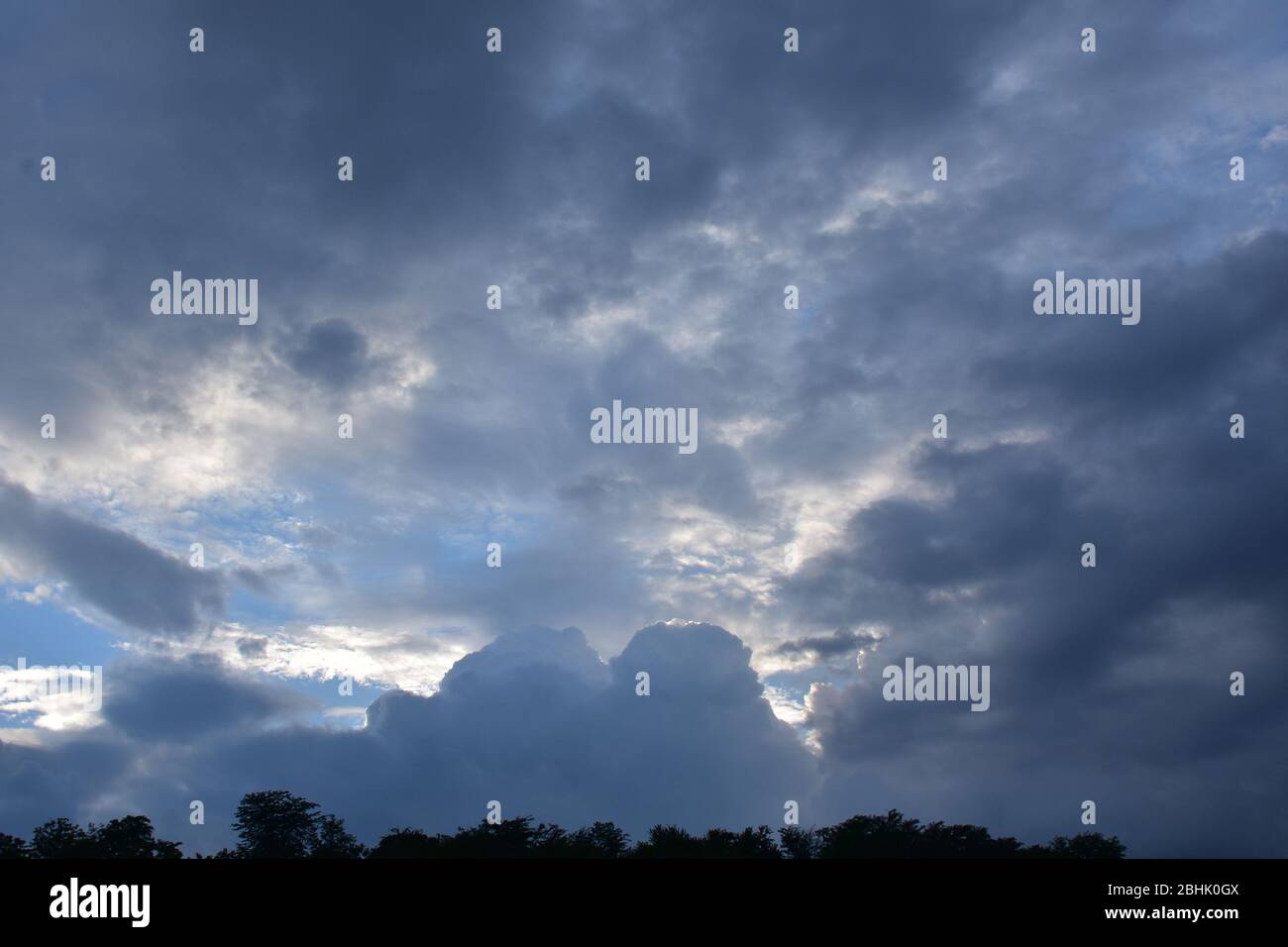 Dramatic cloudy sky with thick, dark clouds partially clearing ...