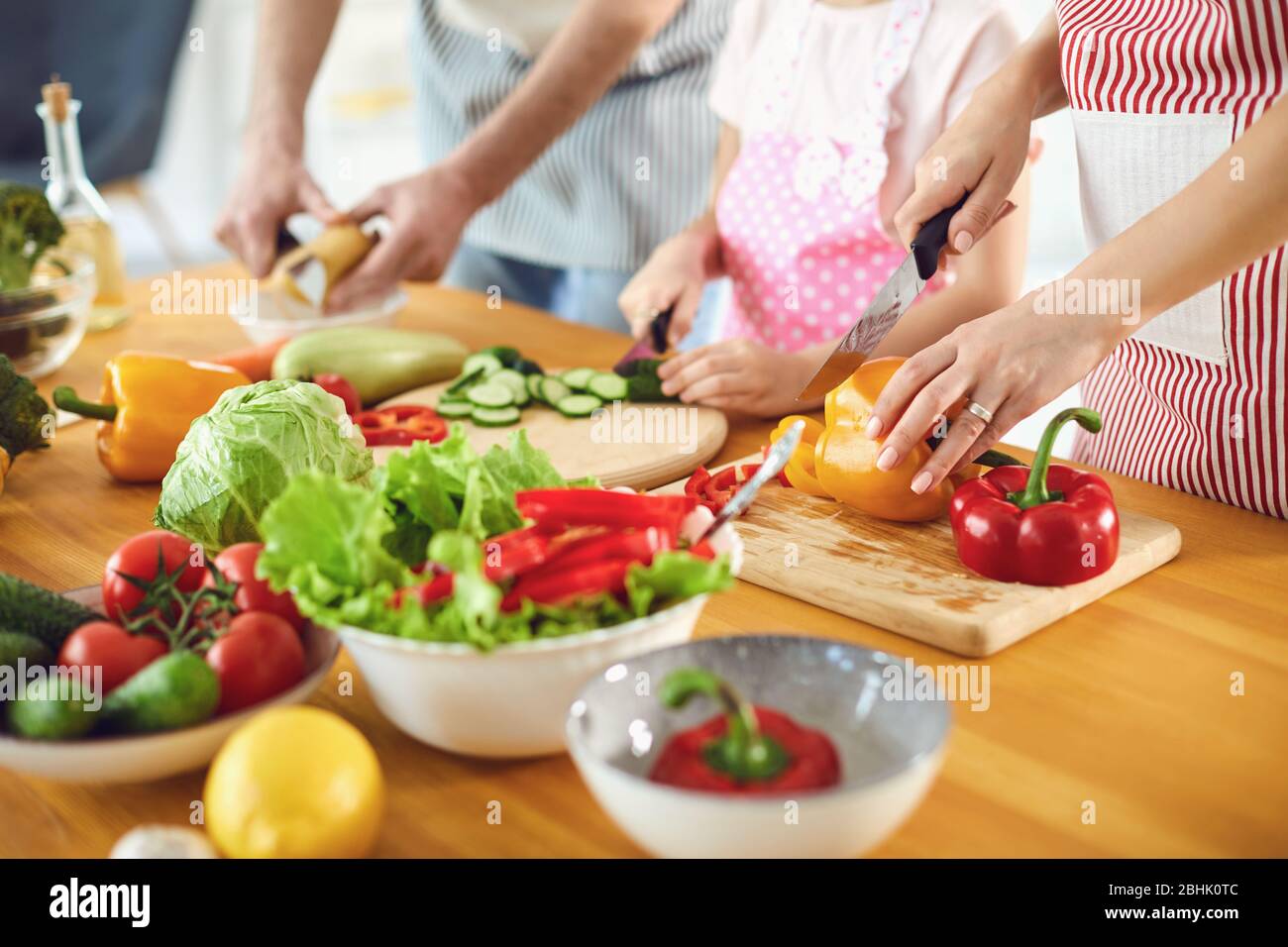 Family cooks fresh vegetables on the table in the kitchen Stock Photo ...