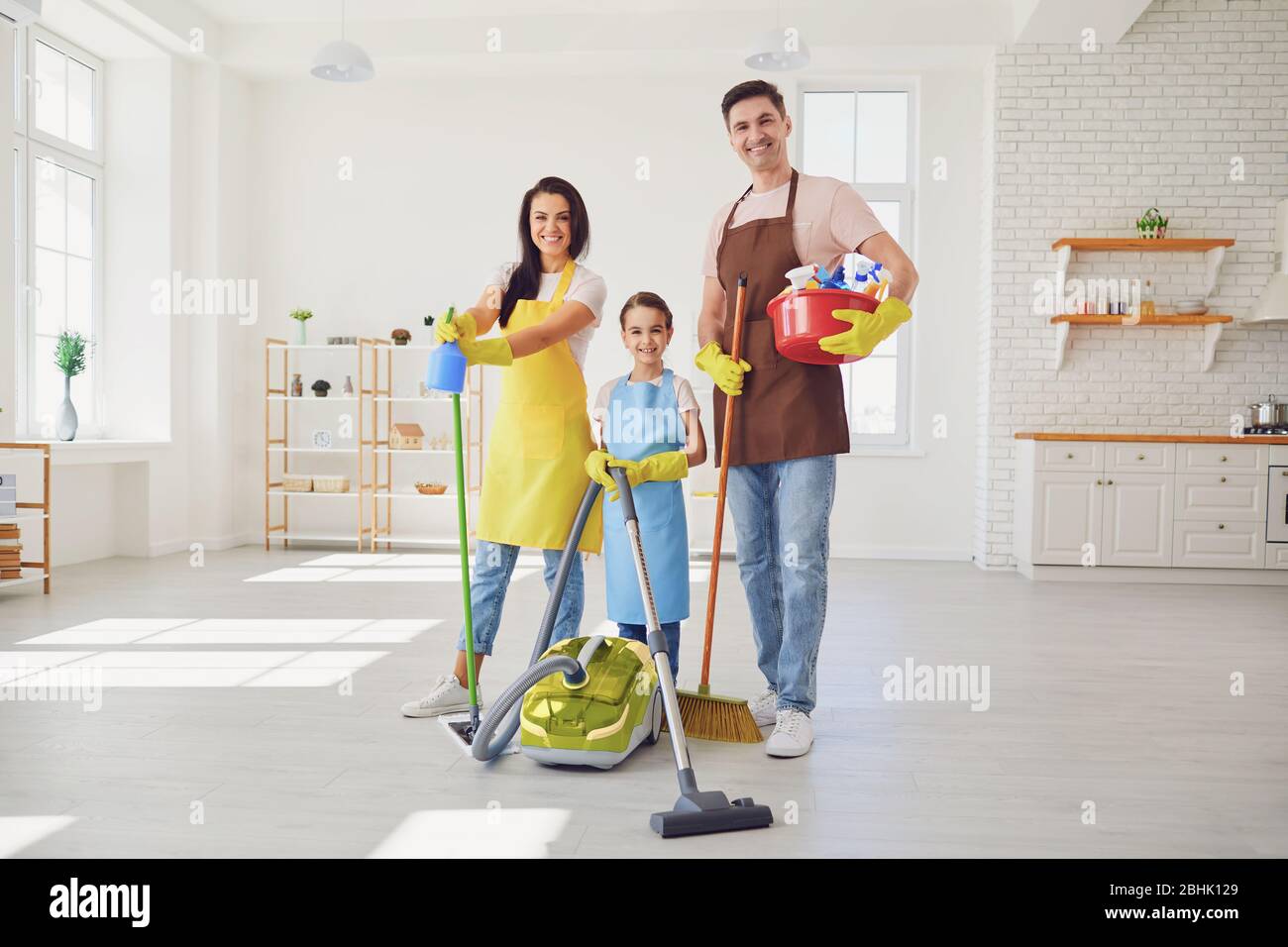 Happy family cleans the room in the house. Mother father and little ...