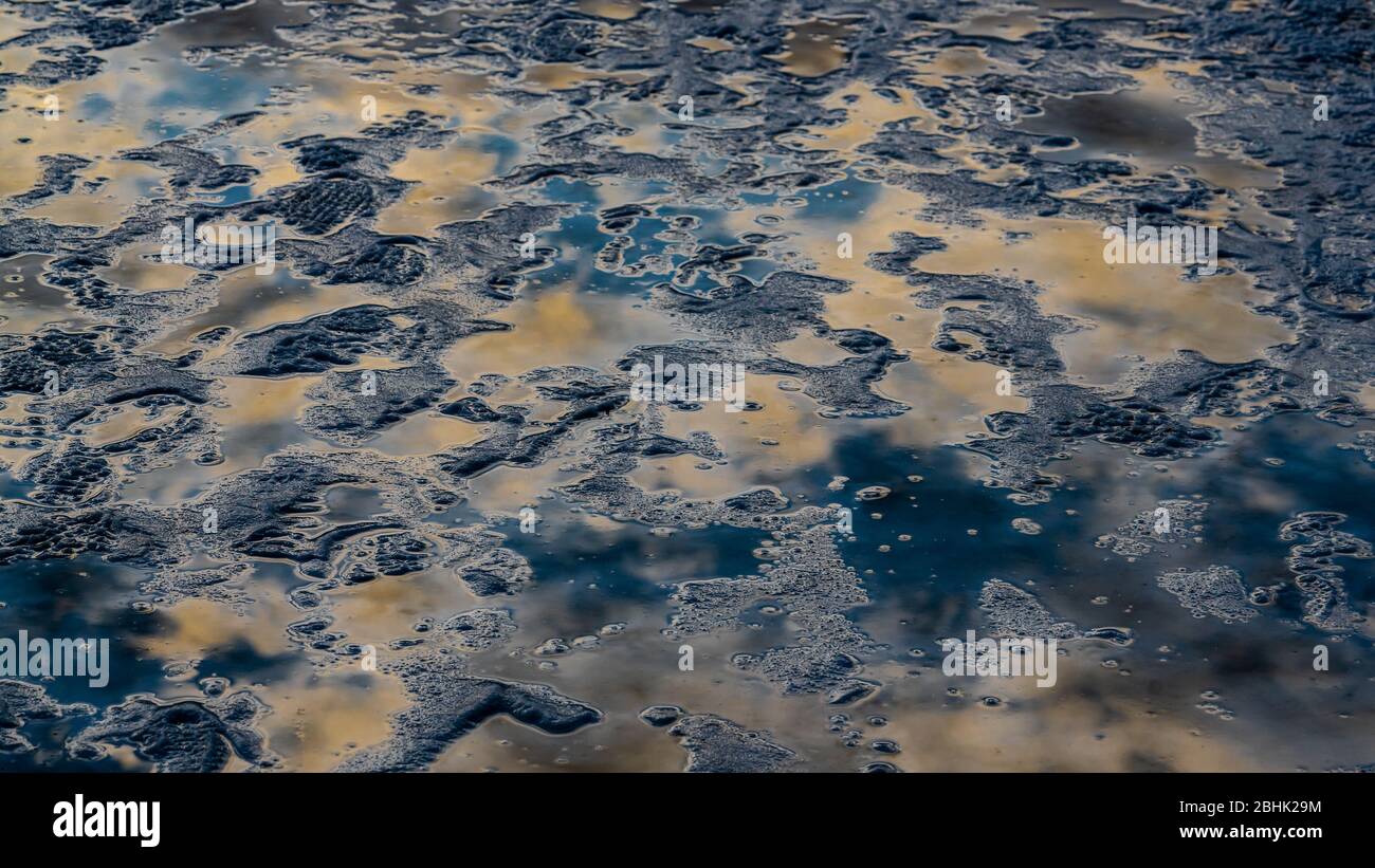 Closeup image of clearing sky reflected in pooled water after a rare ...