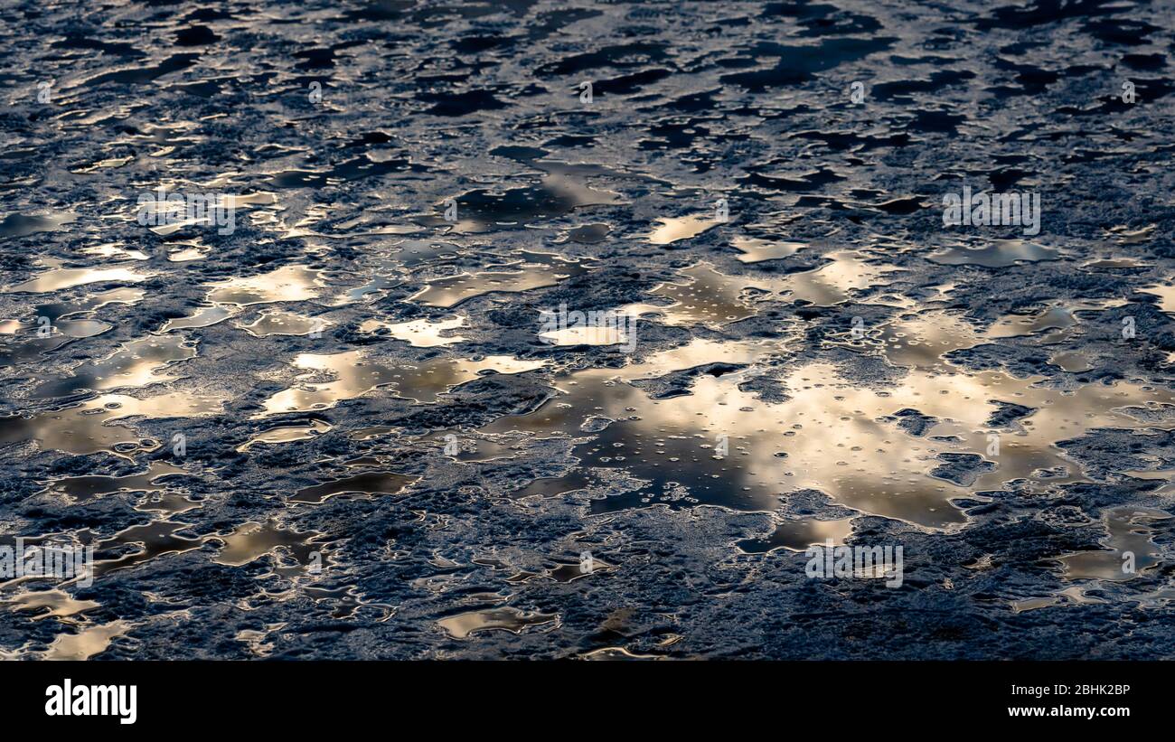 Closeup image of clearing sky reflected in pooled water after a rare ...