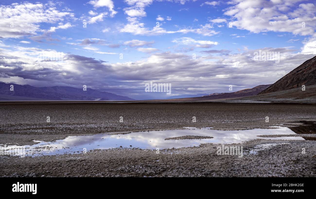 Dramatic sunset skies and reflections in pools that remain after a rare ...