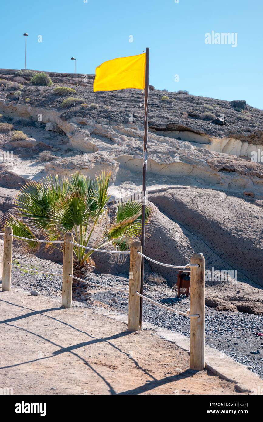 A yellow medium-hazard beach warning flag Stock Photo - Alamy