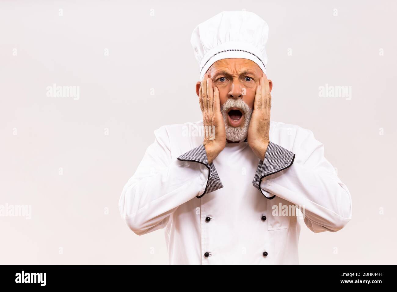 Portrait of shocked senior chef on gray background Stock Photo - Alamy