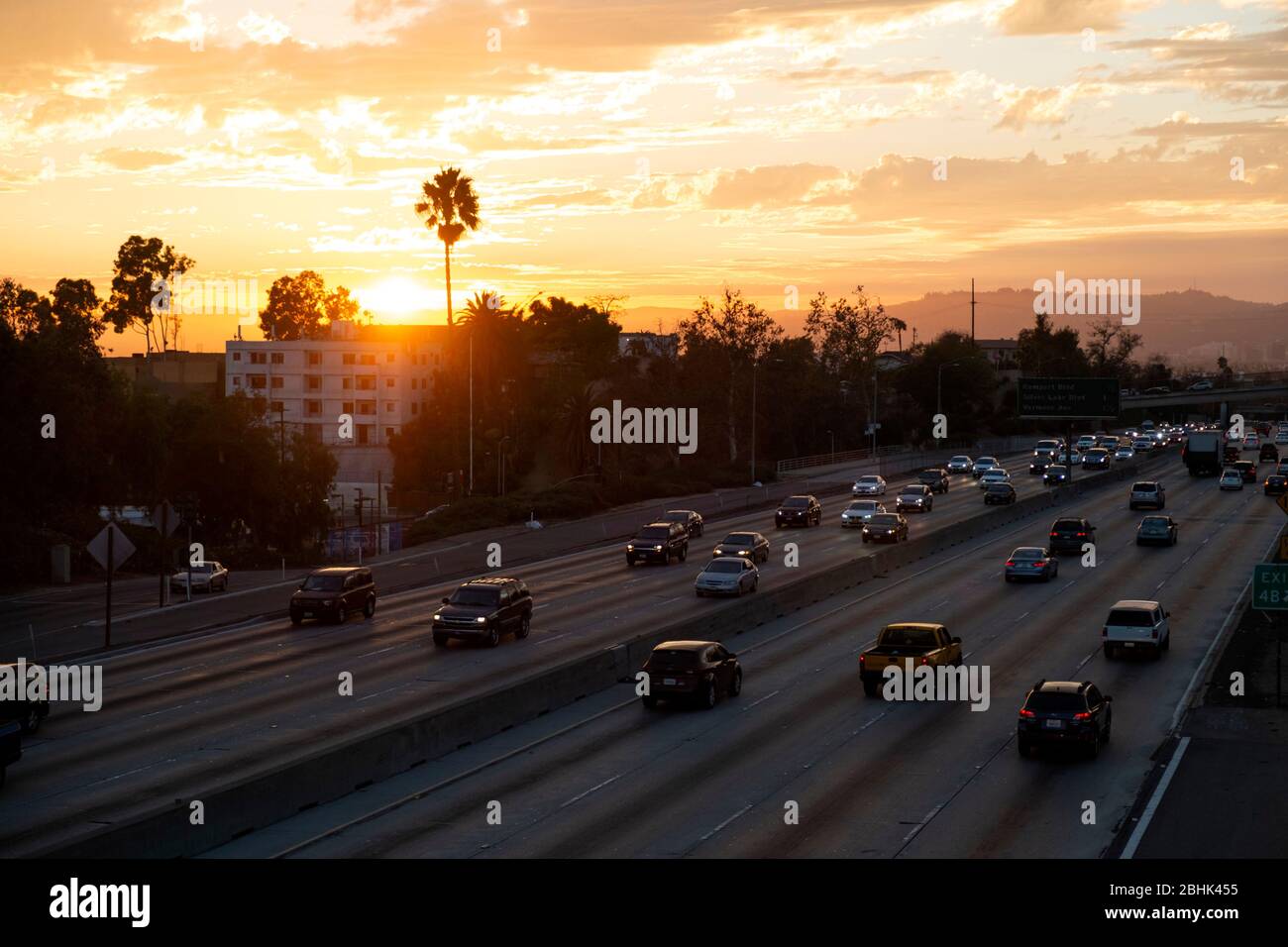 Flowing traffic on the 101 Hollywood freeway near downtown Los Angeles backed by a golden sunset ...