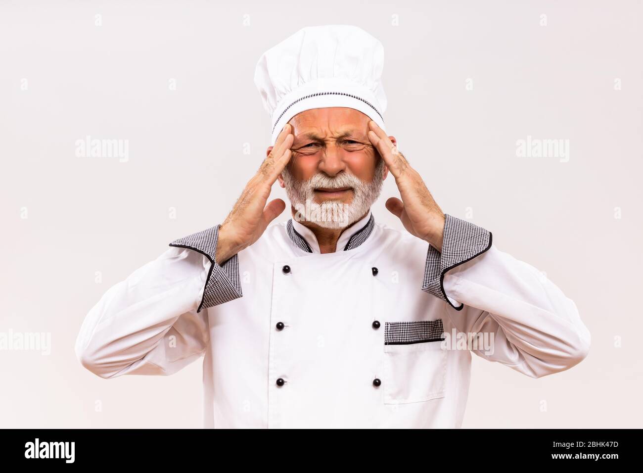 Image of tired senior chef having headache Stock Photo - Alamy